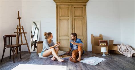 젊은 부부는 새 집으로 이사하고 골판지 상자 근처 바닥에 앉아 피자를 먹는다 사진 Unsplash의 여성 이미지