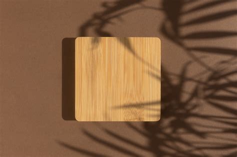 열대 야자수 잎의 그림자가있는 갈색 배경에 나무 연단 기하학적 형태의 추상적 인 최소 장면 화장품을 보여주는 장면 빈 쇼케이스