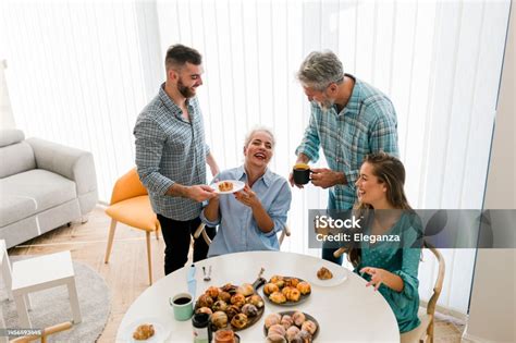 실내에서 함께 식사하는 행복한 가족 아침 식사 중에 식탁에 앉아 웃는 세대 가족 거실에서 함께 식사를 즐기는 행복한 쾌활한 가족 4 명에 대한 스톡 사진 및 기타 이미지