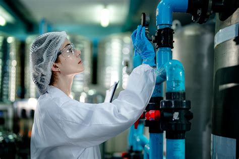 산업 공장에서 역삼투압 기계 시스템의 품질을 확인하는 과학자 여성 노동자는 휴대용 공장을 재활용하기 위해 압력을 측정하여 제어판에서 데이터를 기록합니다 약에 대한 스톡 사진