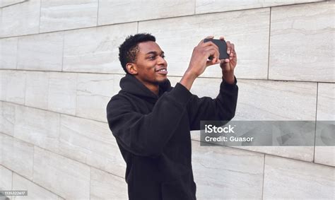 쾌활 한 웃는 아프리카 사람 회색 벽 배경 위에 도시 거리에 전화로 Selfie 그림을 복용 가을에 대한 스톡 사진 및 기타 이미지 Istock