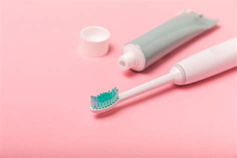 분홍색 배경에 스마트 전동 칫솔 건강을위한 현대 기술 건강한 치아 치과 개념입니다 보조 배터리를 통해 충전되고 스마트폰의 앱으로 제어됩니다 구강 위생 0명에 대한 스톡 사진