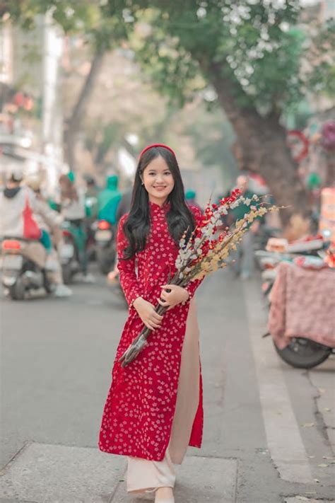 有关傳統 優雅 分裂 坐 垂直拍摄 奧黛 女人 擺姿勢 时尚摄影 樓梯 模特兒 橙色上衣 正装 漂亮 白色的裤子 絲綢 越南服装 辮子 連衣裙 鸳鸯领的