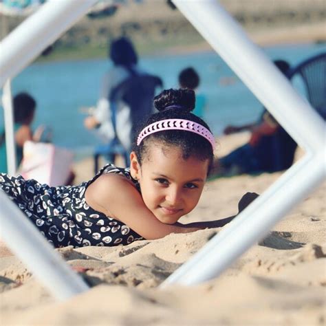 Premium Photo Portrait Of Girl Lying On Sand At Beach