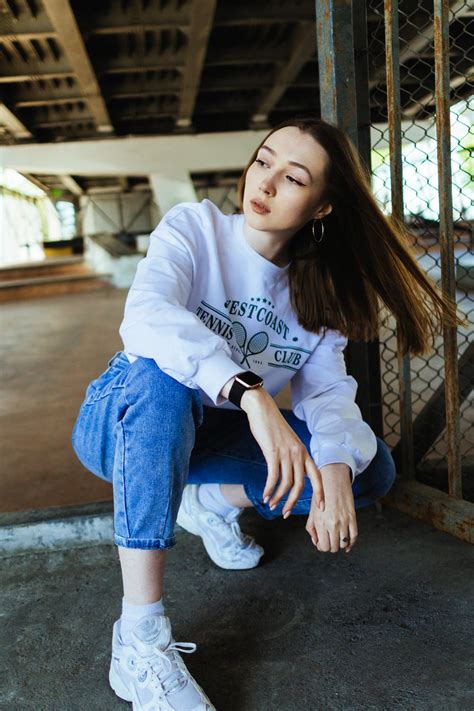 그래픽 스웨트셔츠 긴 머리 다른 곳을 바라보는 데님 도시 패션 도시의 라이프스타일 머리카락의 움직임 모델 사람 사진 촬영 수직 쐈어 스타일 스트리트