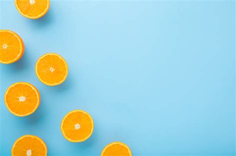 오렌지의 밝은 반쪽 신선한 과일 연한 파란색 테이블 배경에 텍스트에 대한 빈 장소입니다 파스텔 색상입니다 근접 촬영 하향하 보기