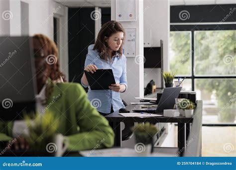 Employee Analyzing Report Comparing Data On Clipboard And Laptop Stock