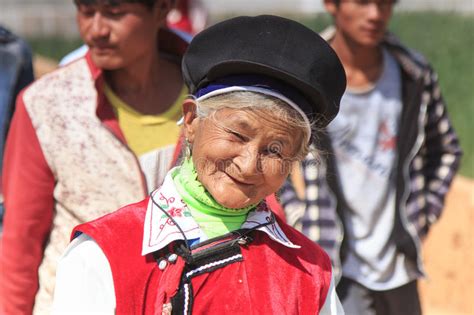 Китайская женщина одела с традиционной одеждой Bai во время фестиваля цветка груши Heqing Qifeng
