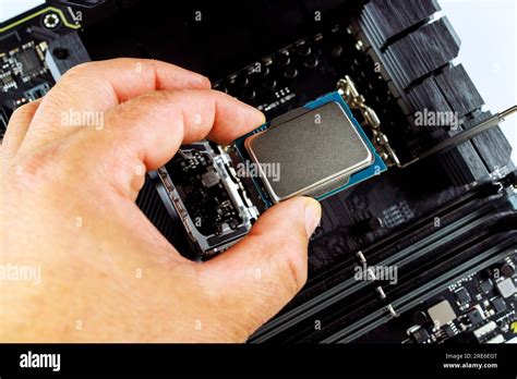 in process of assembling desktop computer technician is plugging cpu into socket on motherboard