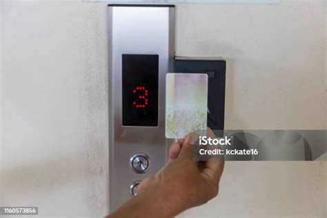 엘리베이터 또는 엘리베이터 출입 통제 를 확보할 수 있습니다 엘리베이터 출입 통제 키 카드를 들고 위 또는 아래로 엘리베이터 바닥의 잠금을 해제 하는 손 만짐에 대한 스톡