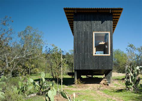 Charred Cabin By Draa Is A Blackened Timber Shelter On Stilts