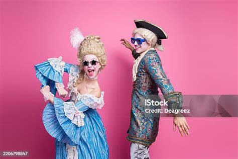 화려한 커플은 화려한 분홍색 배경에 테마 파티에서 화려한 바로크 양식의 의상을 입고 재미 있고 역사적인 스타일을 보여줍니다 16 17 살에 대한 스톡 사진 및 기타 이미지