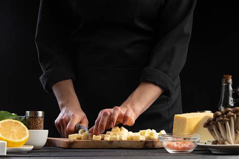 셰프가 마자렐라 치즈를 썰어 맛있고 신선한 샐러드를 준비합니다 채식과 신선한 음식 미식과 요리 조리법 책과 조리법 검은색
