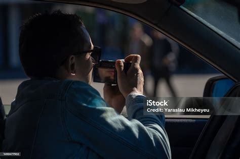 선글라스를 쓴 파파라치 남자 또는 남자가 그녀의 차에 앉아 유명한 사람의 사진을 찍습니다 차에 카메라가 있는 스파이 사립