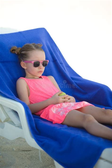 Прелестная маленькая девочка сидя на стуле на тропическом Стоковое Изображение изображение