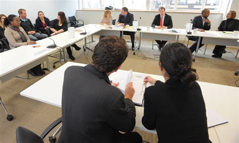 An Nmc Hearing With Tables In A U Shape The Panel Members Facing The Camera And Being Addressed