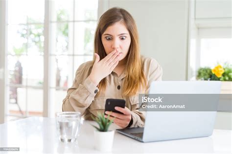 스마트 폰과 컴퓨터 커버를 사용 하 여 아름 다운 젊은 여성이 실수에 대 한 수치와 충격 두려움의 표현 침묵에 무서 워 비밀 개념 가리기에 대한 스톡 사진 및 기타 이미지