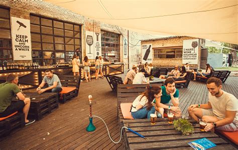 젊은 사람들은 야외 거리 음식 축제 기간 동안 팝업 레스토랑에서 음료에 대 한 회의 공원에 대한 스톡 사진 및 기타 이미지