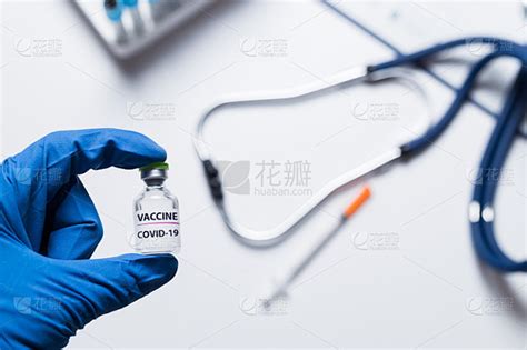 医生、科学家或护士手戴蓝色手套，手持小瓶冠状病毒疫苗，为疾病暴发接种疫苗、药物和药物概念