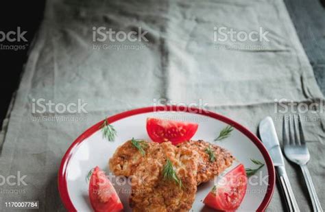 육즙이 많은 고기 닭갈비와 토마토를 포크와 나이프와 함께 제공되는 심플한 가벼운 린넨 배경에 흰색 접시에 얹어 놓습니다 0명에 대한 스톡 사진 및 기타 이미지 Istock