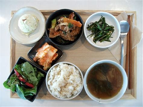 A Wooden Tray Topped With Bowls And Plates Filled With Different Types