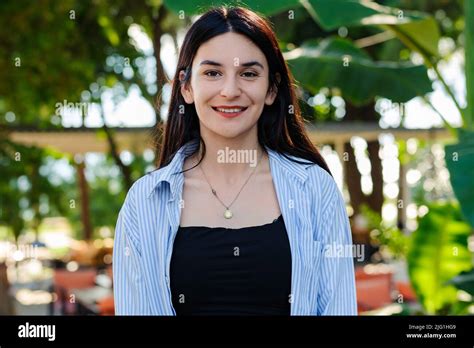 Portrait Of Cute Brunette Woman Wearing Striped Shirt Standing On City