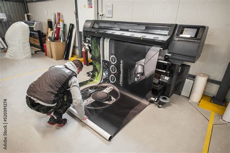 Technician Operator Works On Large Premium Industrial Printer Plotter Machine Stock Photo