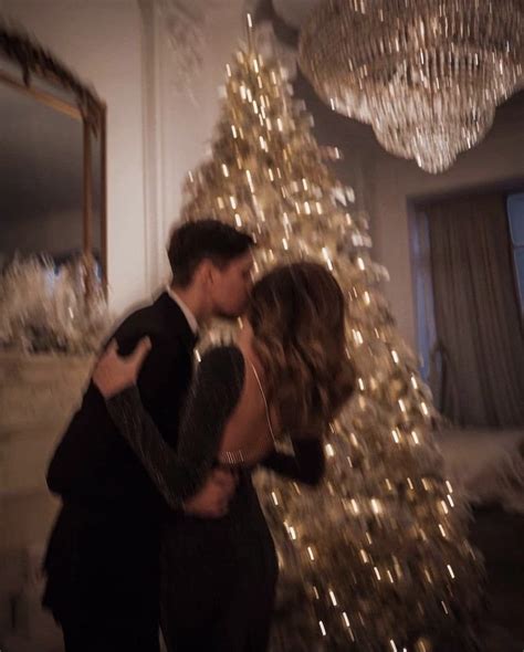 Cupple Kissing At Elegant House There Is A Christmas Tree Behind Them