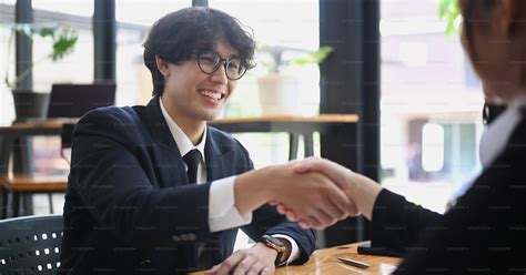 정장을 입은 웃는 사업가가 협상 후 비즈니스 파트너와 악수하고 있다 사진 Unsplash의 양복 이미지