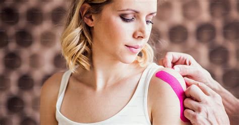 젊은 여성 환자에게 테이프를 붙이는 알아볼 수 없는 남성 물리치료사의 손 닫다 사진 Unsplash의 어깨 이미지