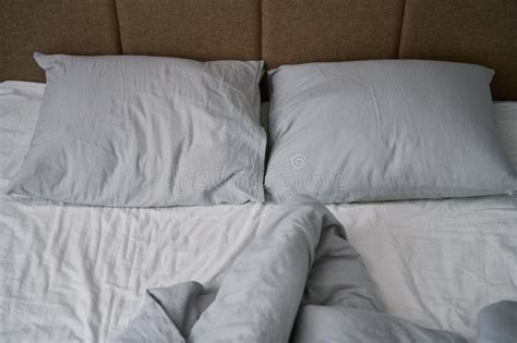 Crumpled Bed With Pillows Blanket And Crumpled Sheets In Bedroom Stock