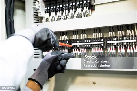 전기 기술자는 제어 캐비닛에 시스템 배전반 전기 시스템의 전선을 연결하기 위해 작동합니다 개폐 장치에 대한 스톡 사진 및 기타