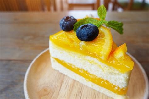 먹고 지방 개념을 사랑 하는 블루베리와 민트 나무 플레이트 배경에 달콤한 디저트 케이크 위에 오렌지 케이크 감귤류 과일에 대한