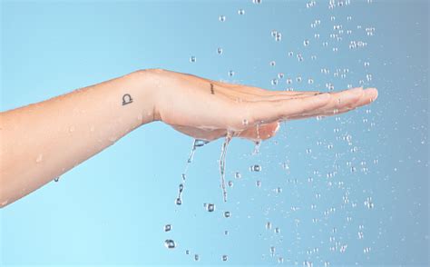 파란색 배경에 건강한 스킨케어 개인 위생 및 웰빙을 위해 물 튀김 샤워 및 아름다움으로 손을 청소하는 여성 욕실에서 손 손바닥 및 몸을 씻기위한 물방울 근접 촬영 20 24