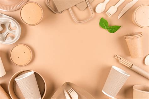 Kraft 종이 도구 나무 칼 붙이 세트 종이 컵 접시 가방 및 복사 공간이있는 밝은 갈색 배경 위에 식품 용기로 만든 프레임 지속 가능한 식품 포장 위의보기 원형에 대한