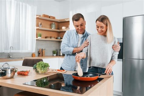 Fre R Comida En Una Sart N Pareja Preparando Comida En Casa En La Cocina Moderna Foto Premium