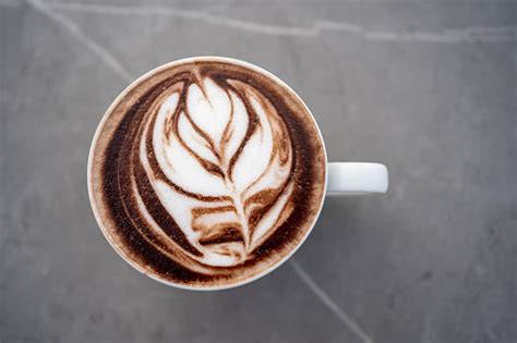 라떼 컨셉의 컵을 들고 여자의 손에 라떼 예술 카페테리아 테이블에 앉아있는 동안 신선한 라떼 한잔 0명에 대한 스톡 사진 및 기타 이미지 Istock