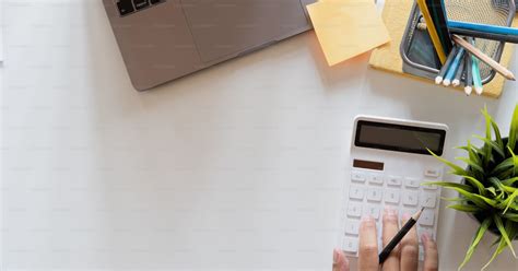 복사 공간 계산기 및 흰색 책상 배경에 화분에 심은 식물이 있는 작업장에서 계산기를 사용하는 회계사의 상위 뷰 손 회계 작업장 개념 사진 Unsplash의 계산기 이미지