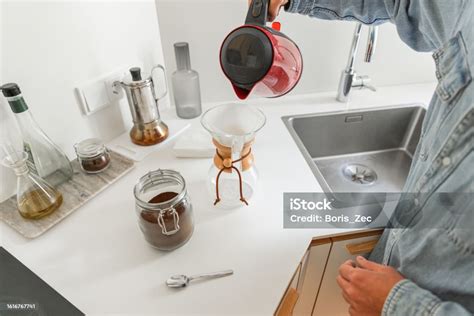 부엌에서 커피 메이커와 물방울 주전자를 사용하여 커피를 준비하는 젊은 남자 출근 전 아침 루틴 30 34세에 대한 스톡 사진 및