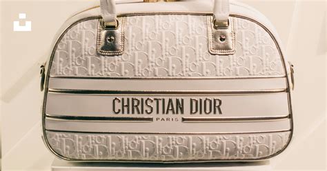 테이블 위에 놓인 화이트 크리스챤 디올 백 사진 Unsplash의 무료 스타일 이미지