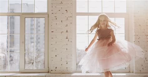아름다운 드레스를 입은 귀여운 소녀가 밝은 햇볕이 잘 드는 방에서 춤을 추고 있다 사진 Unsplash의 유행 이미지