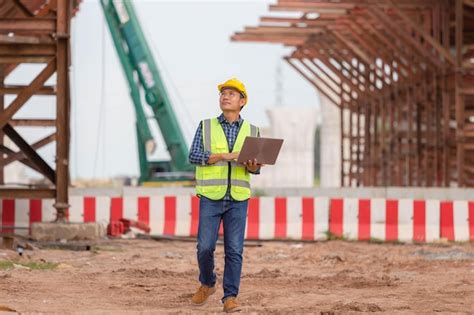 Premium Photo Engineer Checking Project At The Building Site Man In Hardhat With Laptop At The
