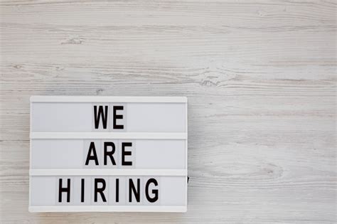 우리는 고용하고 있다 흰색 나무 배경에 현대 보드에 단어 상단 보기 오버 헤드 위에서 평평한 누워 텍스트의 공백입니다 구인 중에 대한 스톡 사진 및 기타 이미지 Istock