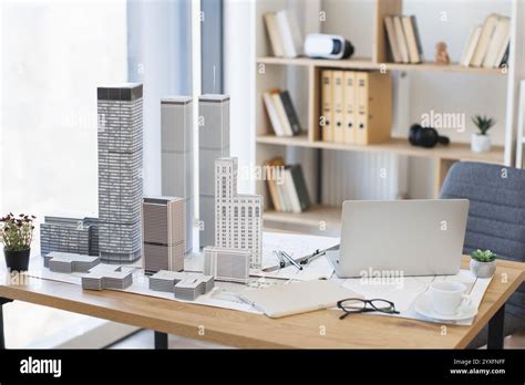 Modern Office Desk Features Architectural Model And Laptop Setup Bright Workspace Includes