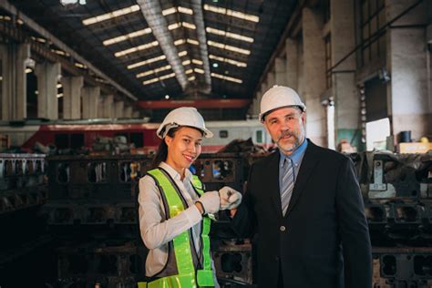엔지니어의 초상화는 공장에서 일하고 있습니다 기계의 준비 상태를 수리하고 검사하는 데 도움을 주는 작업자 기계 기술자가 오작동하는 엔진을 유지 관리하고 있습니다 팀워크에