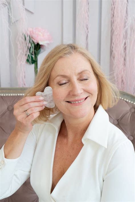 A Woman Is Using A Gua Sha Tool For A Facial Massage Promoting