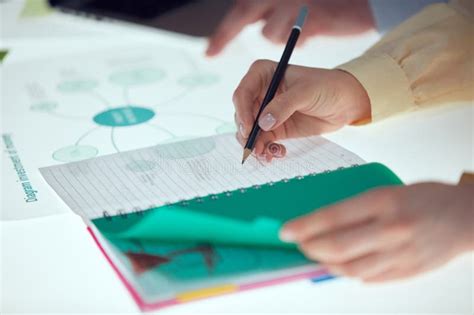 Female Hands Making Notes At Notebook During Brainstorming Business