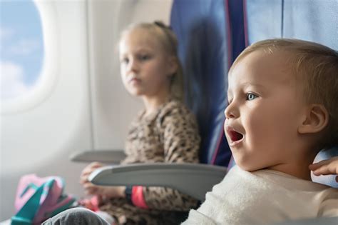 비행기로 여행 귀여운 사랑스러운 형제 남매의 쌍 소년과 소녀는 비행 중에 항공기 안에 앉아있다 테이블로 만화를 보는 아이들 행복한 가족 여행 컨셉 2 3 살에 대한 스톡