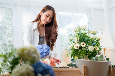 중소기업 아시아 여성 플로리스트 미소가 꽃 가게에 꽃을 배열합니다 꽃 디자인 가게 행복 미소 젊은 아가씨가 고객을위한 꽃병을 만들고 가정 사업에서 꽃 작업을 준비합니다 25