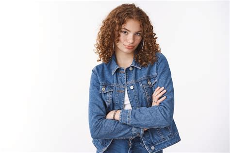 Глупая милая стильная рыжая девушка с веснушками прыщами наклоняющая голову игриво сжимающая